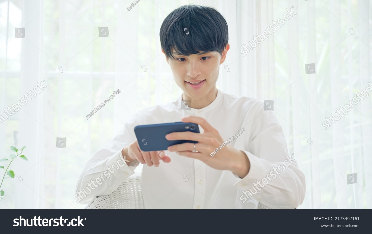 Asian man watching a smart phone in house._站酷海洛_正版图片_视频_字体_音乐素材交易平台_站酷旗下品牌