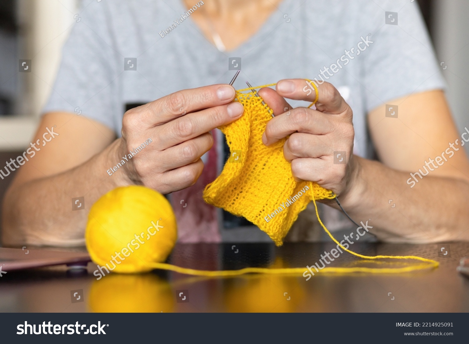 adult mature senior attractive woman knits warm clothes from yellow ...