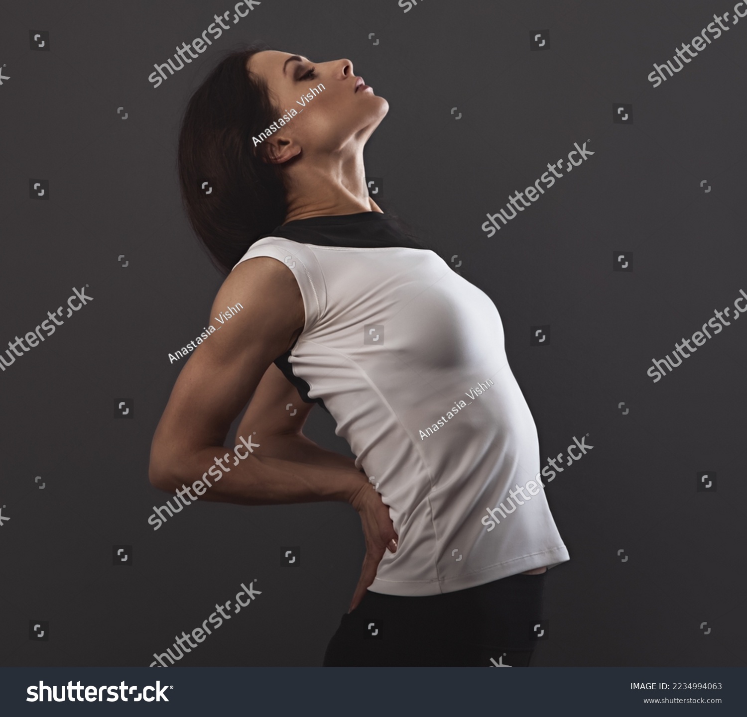 Strong sporty woman doing the arms and shoulders stretching arch ...