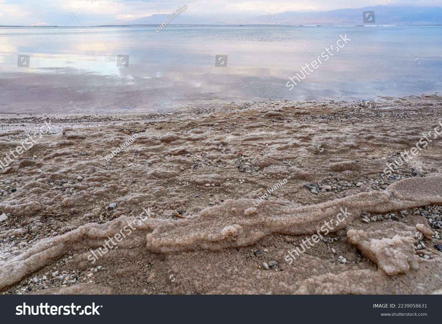 Sand and stones covered with crystalline salt on shore of Dead Sea ...