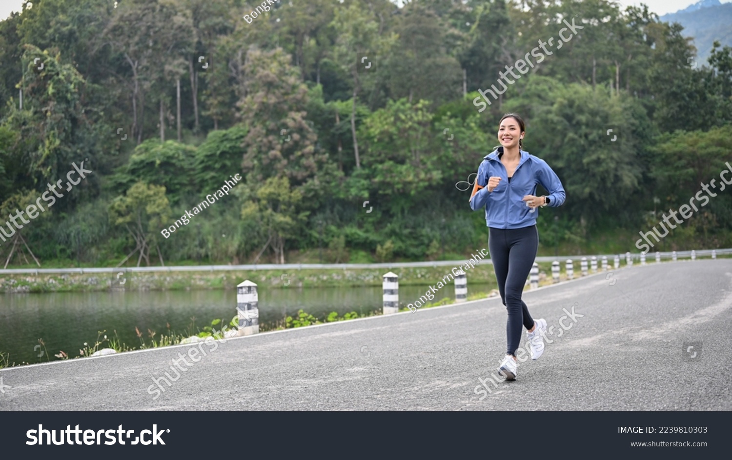 Sporty and active millennial Asian female jogger or runner in comfortable sportswear enjoys ...