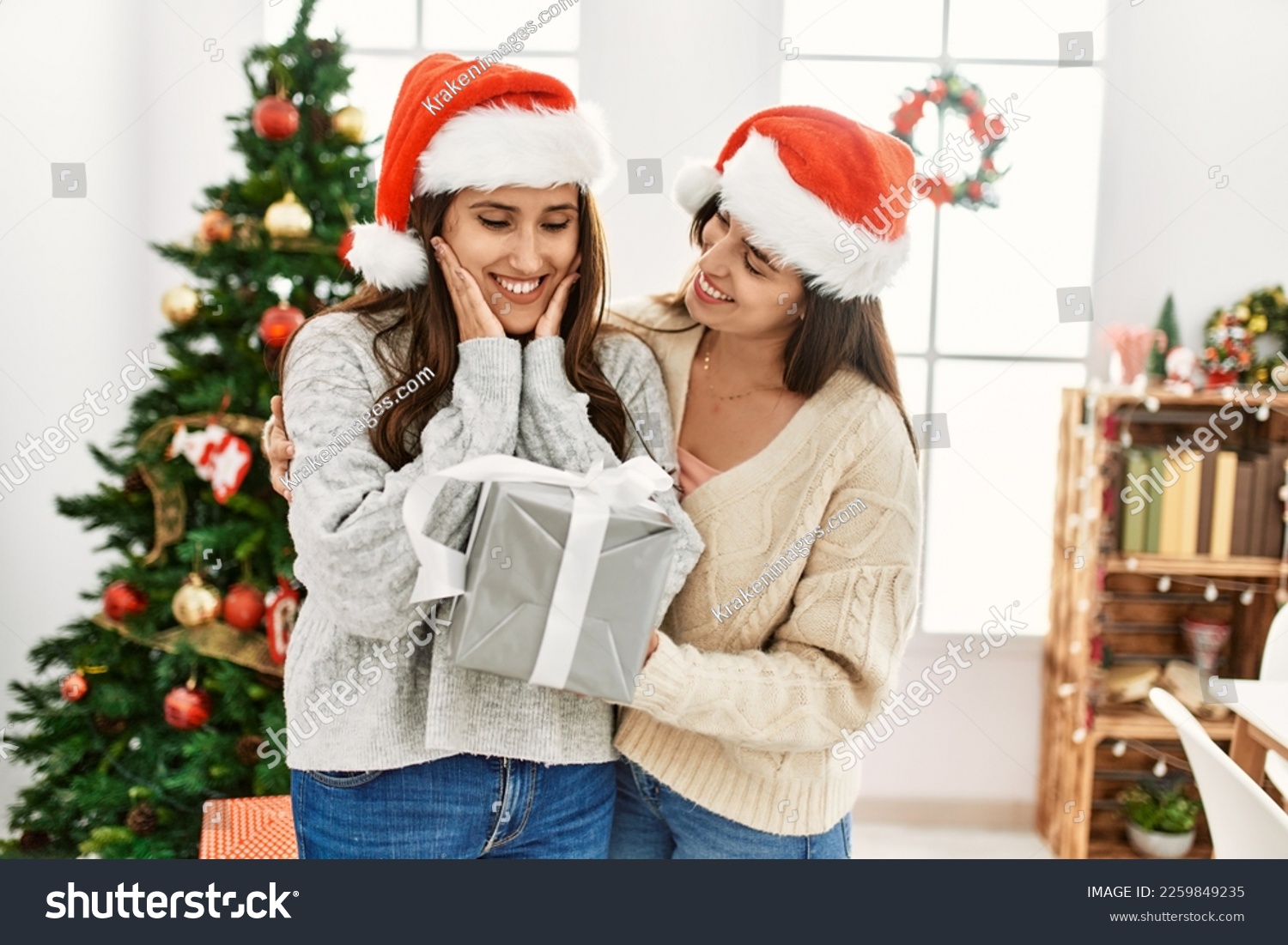 Two women surprise with gift standing by christmas tree at home_站酷海洛_正版图片_视频_字体_音乐素材交易平台_站酷旗下品牌