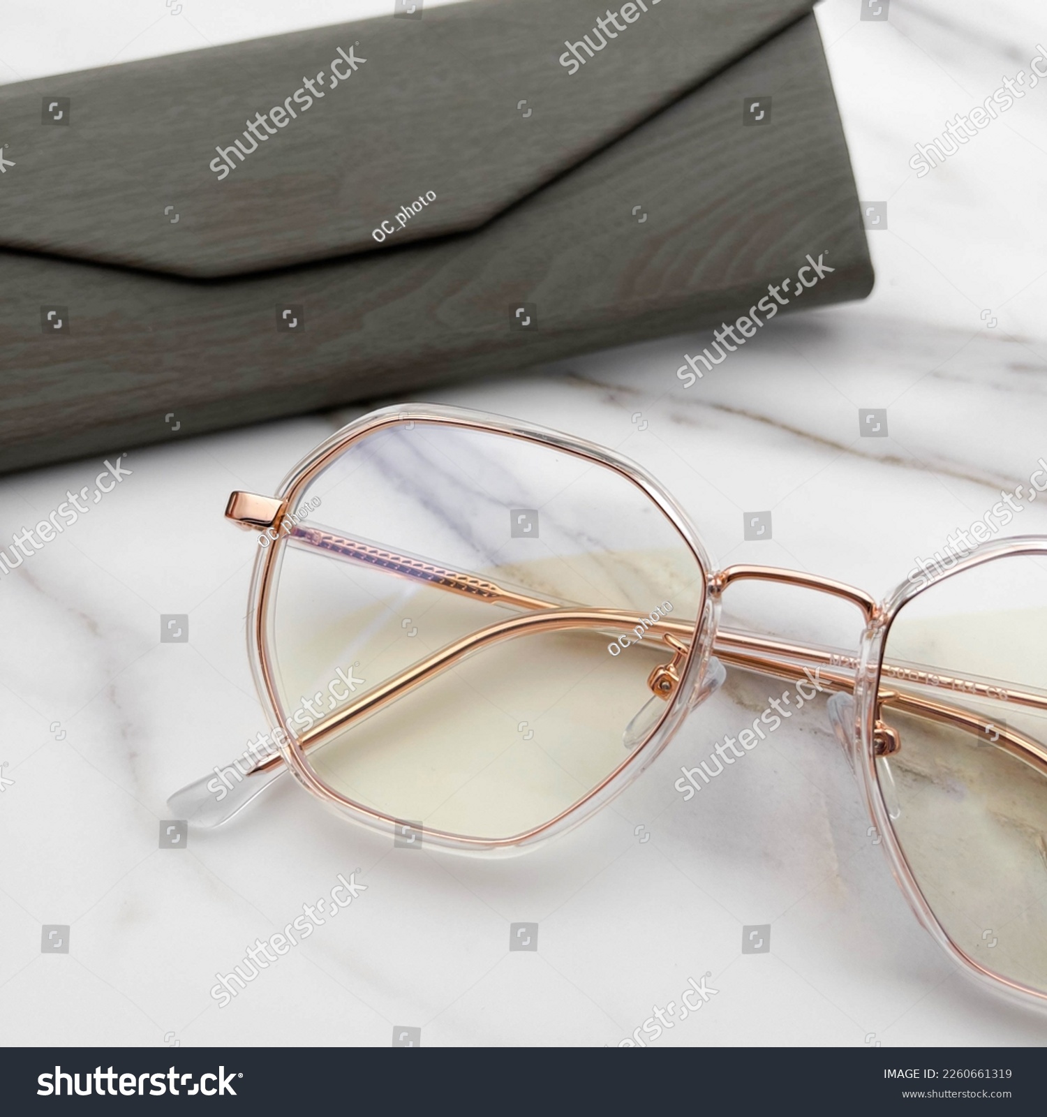 A glasses on a marble table with some decorations on the side there is ...