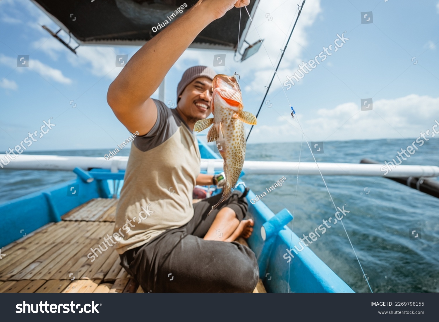 Fishermen catch grouper fish in the sea while fishing using a small ...