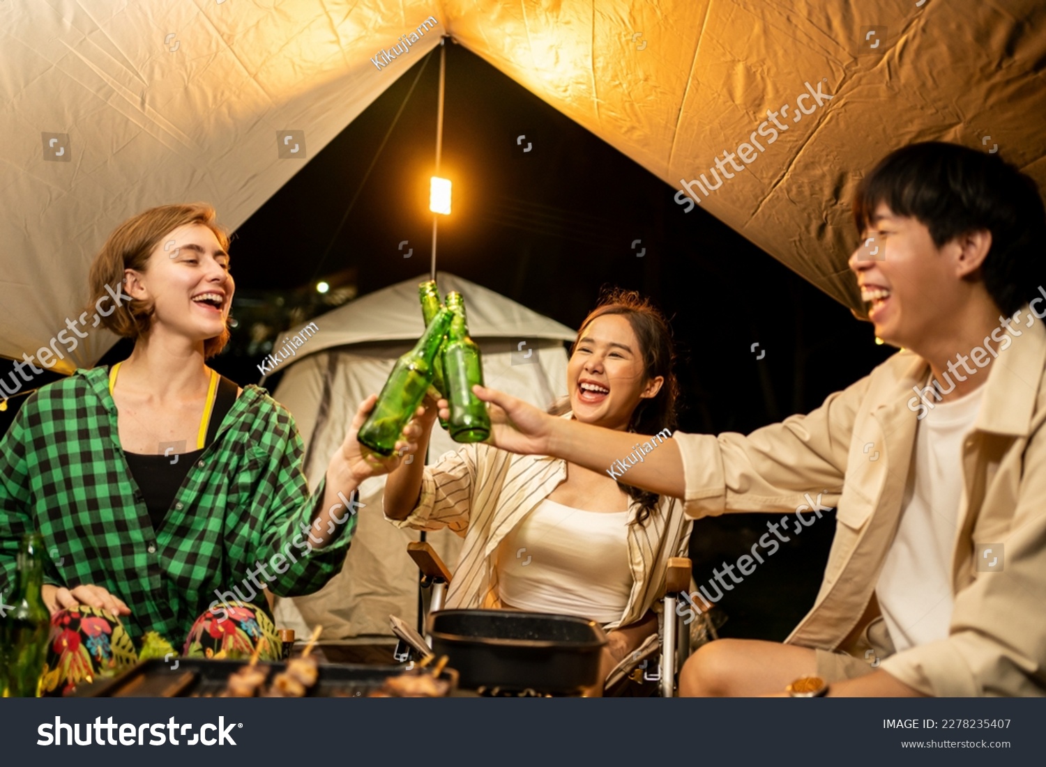 Travel Group of Diverse People Enjoy Camping Tent clinking beer bottles with Friends Hang Out ...