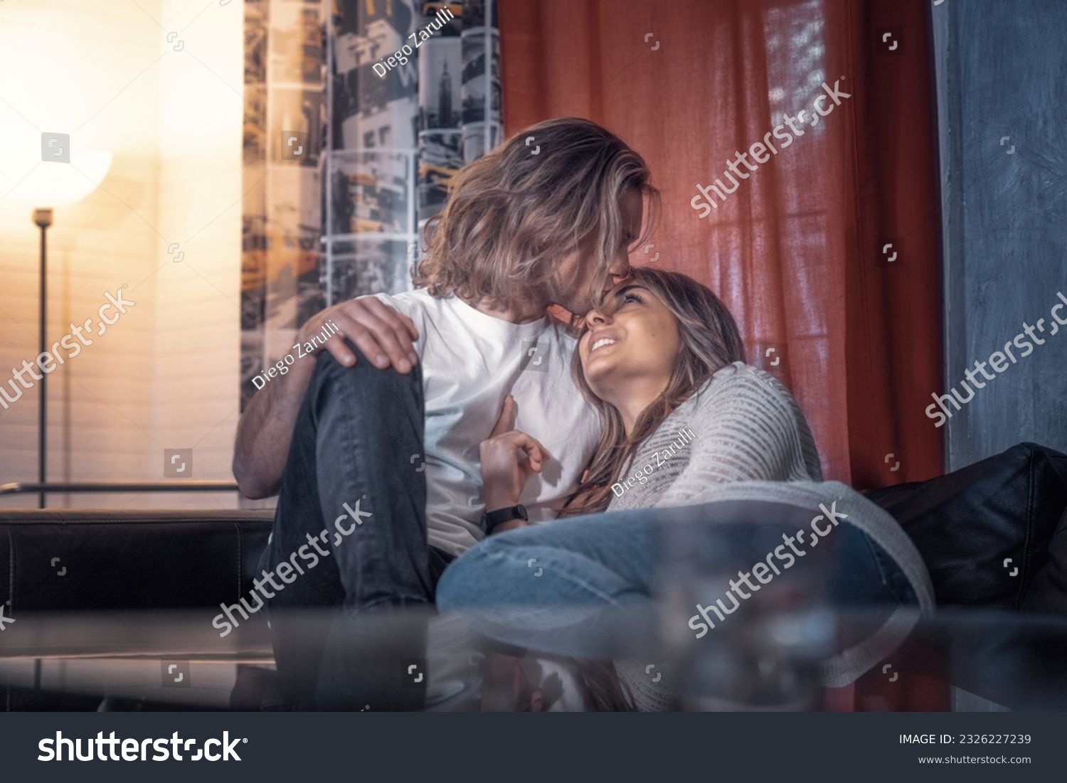 Inside house couple shooting sitting on sofa relaxing and smiling - Yellow and blue atmosphere ...