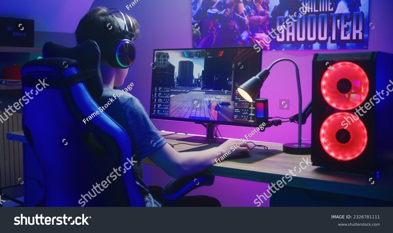 Young gamer in headphones plays in first person shooter on computer. Online video game live ...