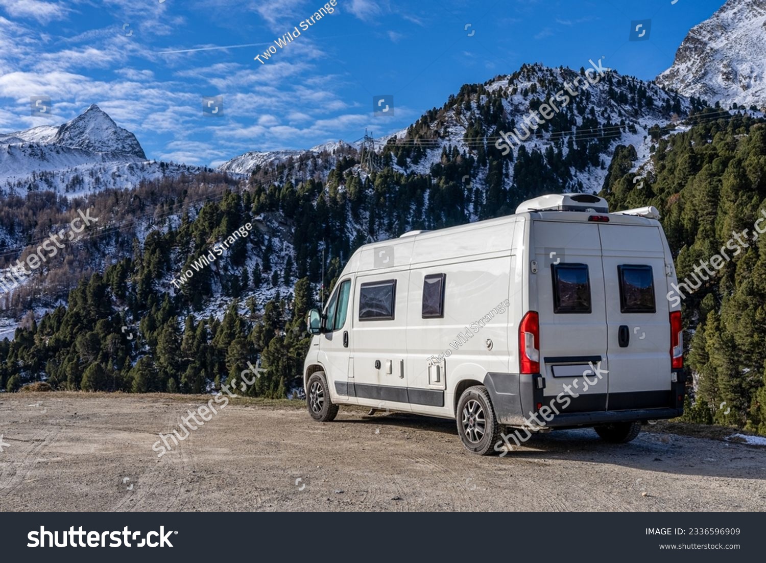 6m long white camper van in the mountains. The Camper is parked in an ...