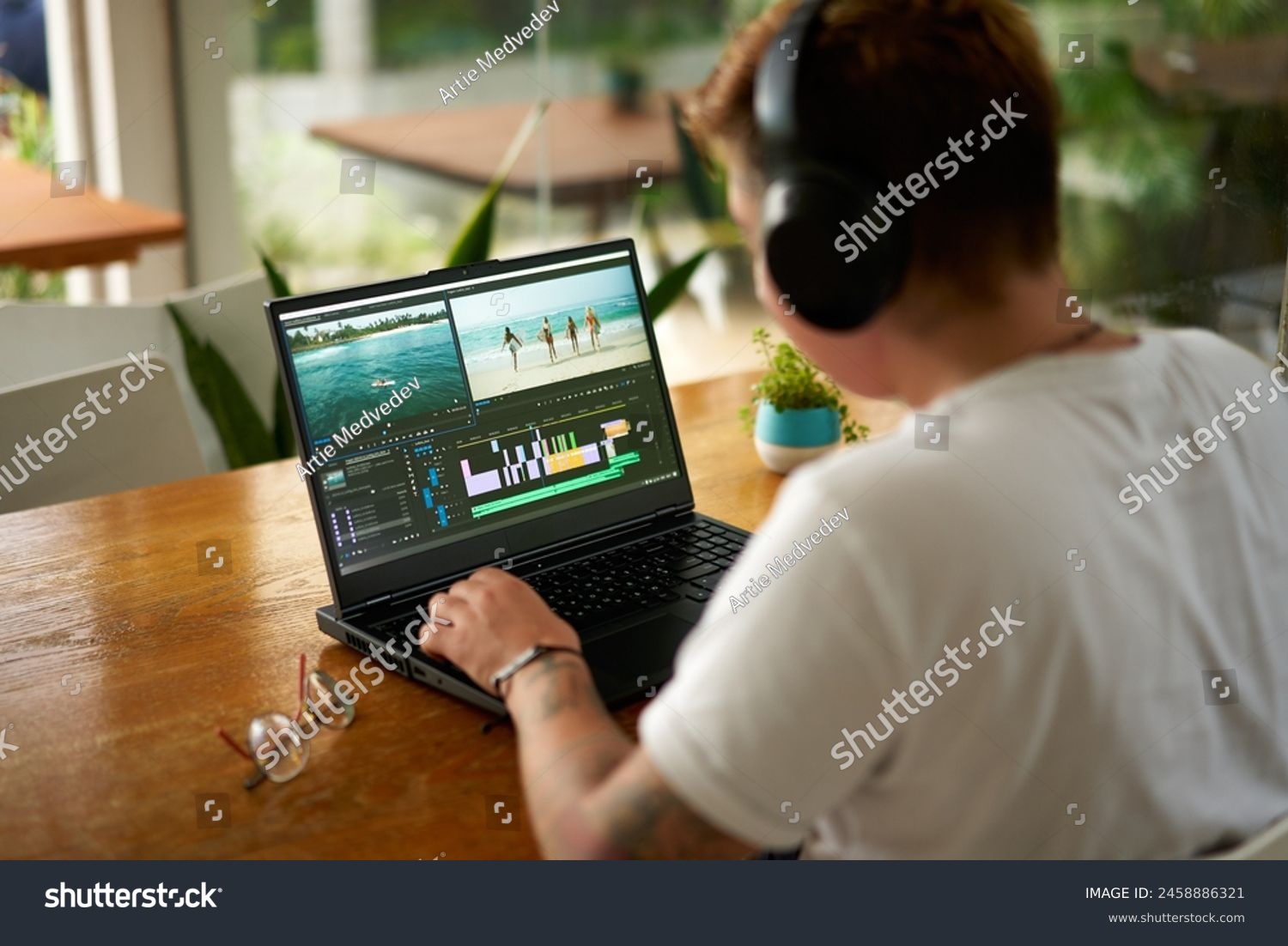 Professional video editor works on laptop with editing software ...