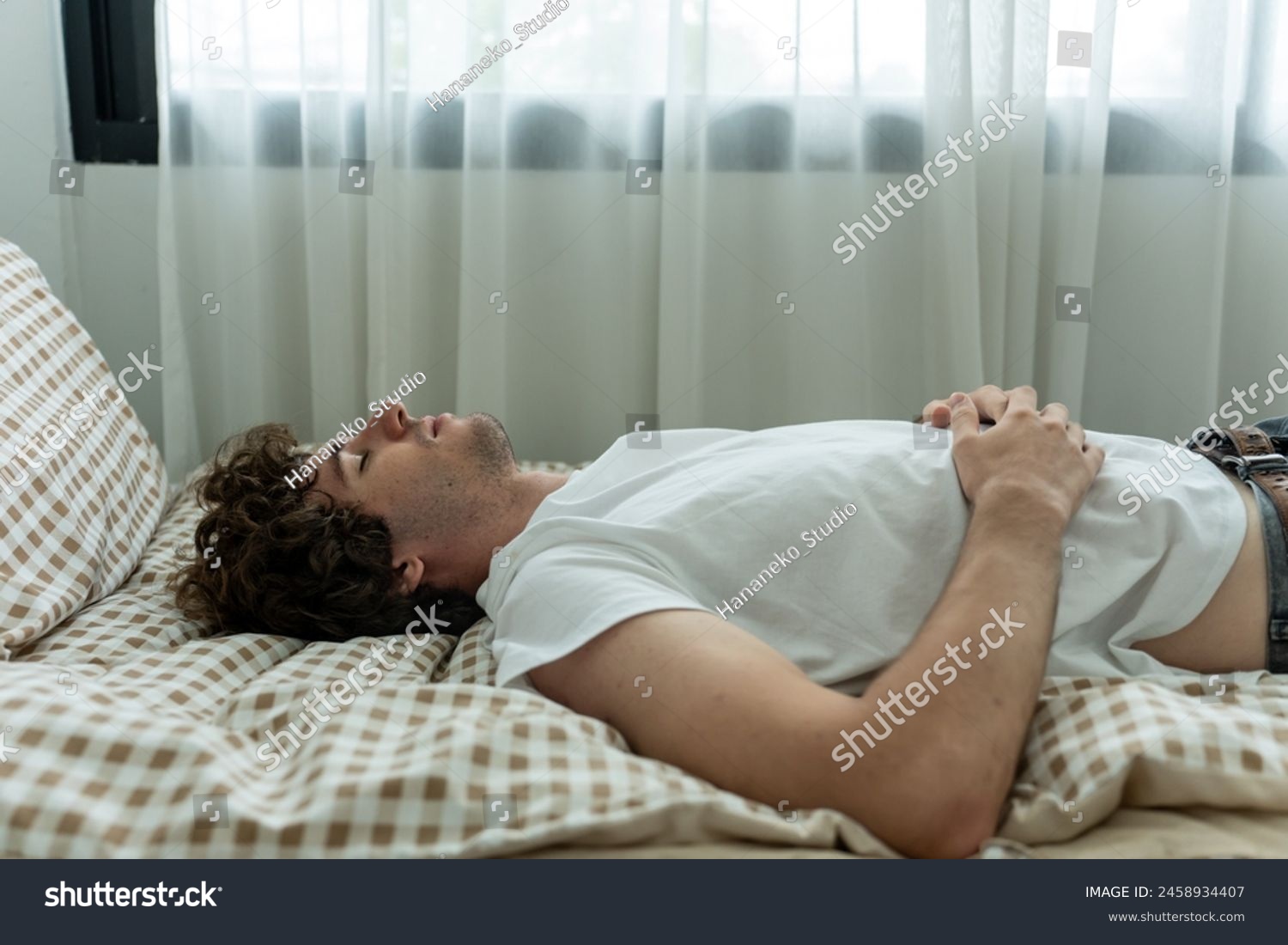 Caucasian handsome man lying down on bed in the morning with happiness ...