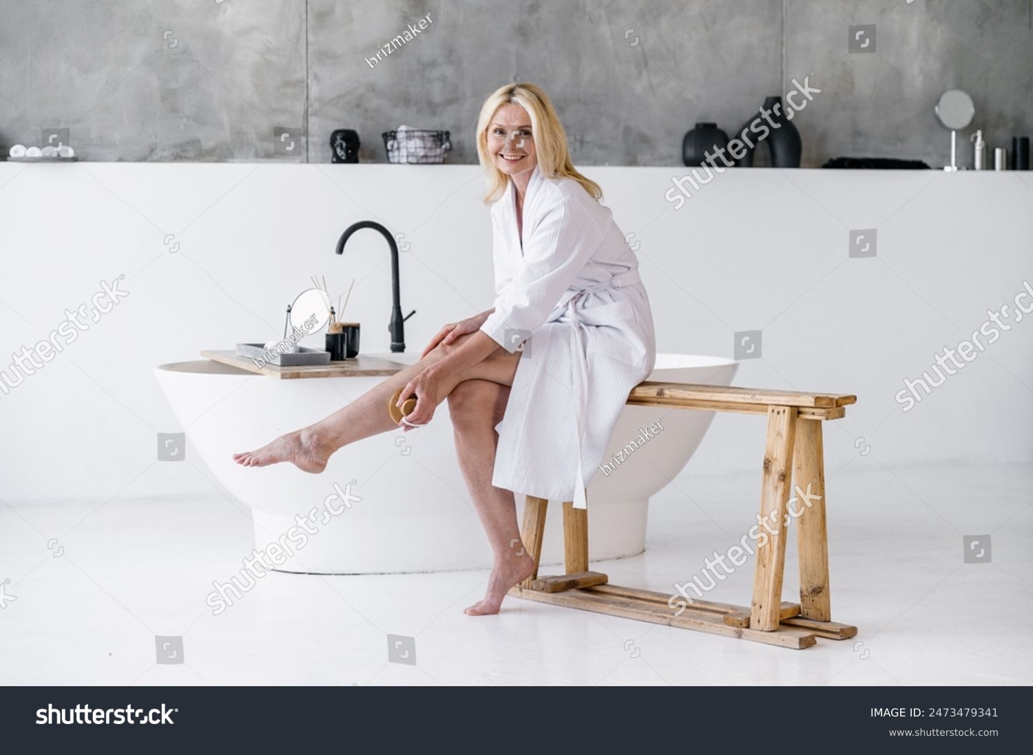 Dry massage at home. Smiling mid age woman spending morning in modern ...