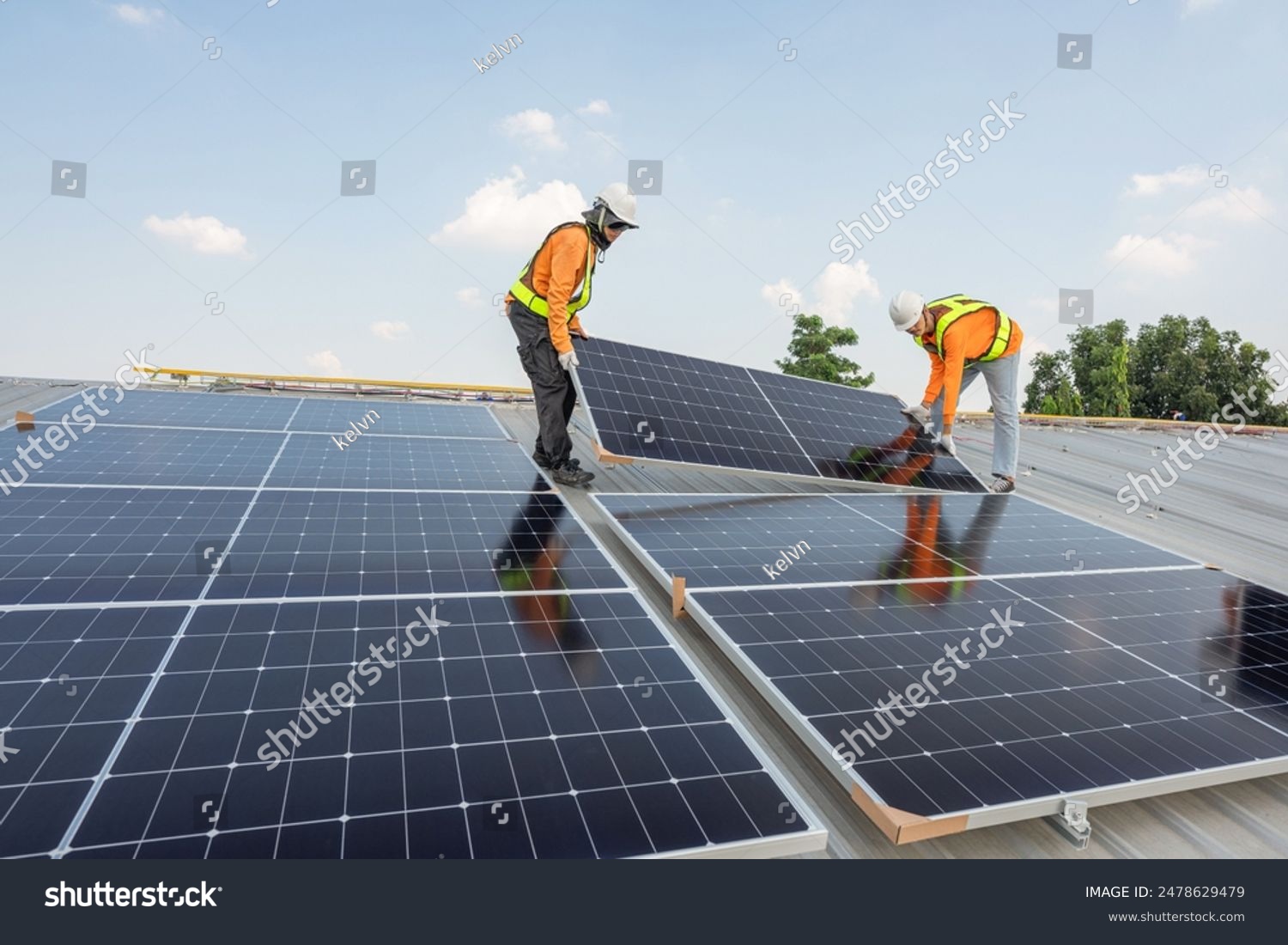Men technicians carrying photovoltaic solar moduls on roof of factory ...