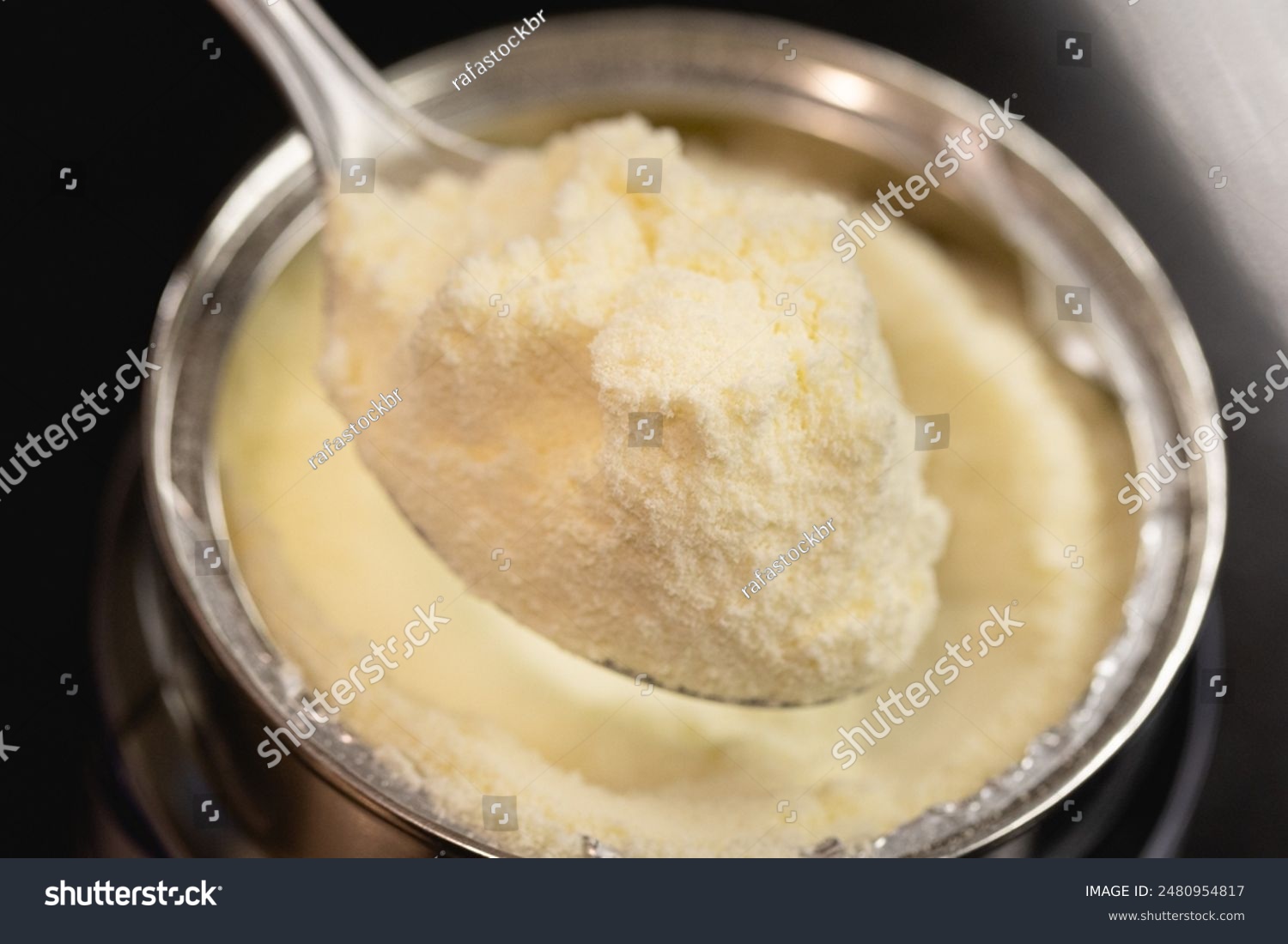 A spoonful of powdered milk. View from above. A can of powdered milk in ...