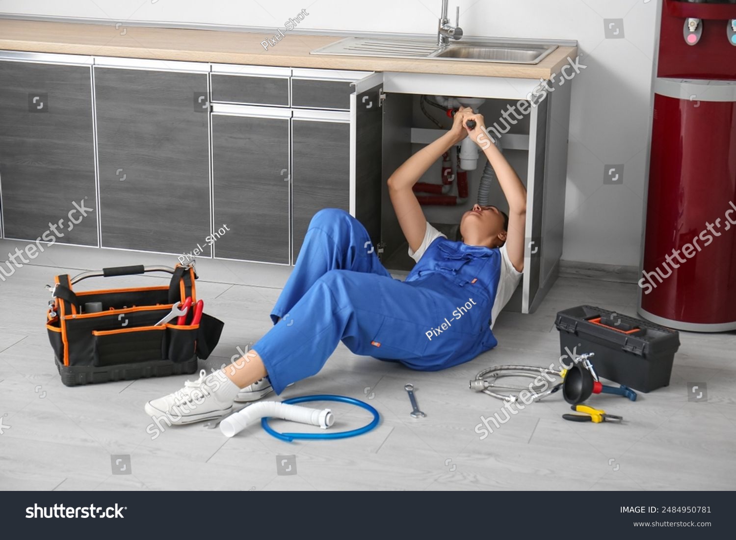 Female plumber with pipe wrench fixing sink in kitchen_站酷海洛_正版图片_视频_字体_音乐素材交易平台_站酷旗下品牌