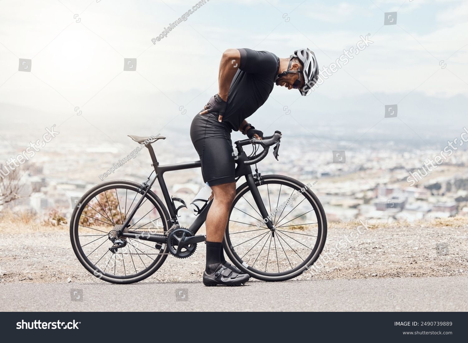 Man athlete and cycling with bike back pain and mountain road with sports injury exercise or ...