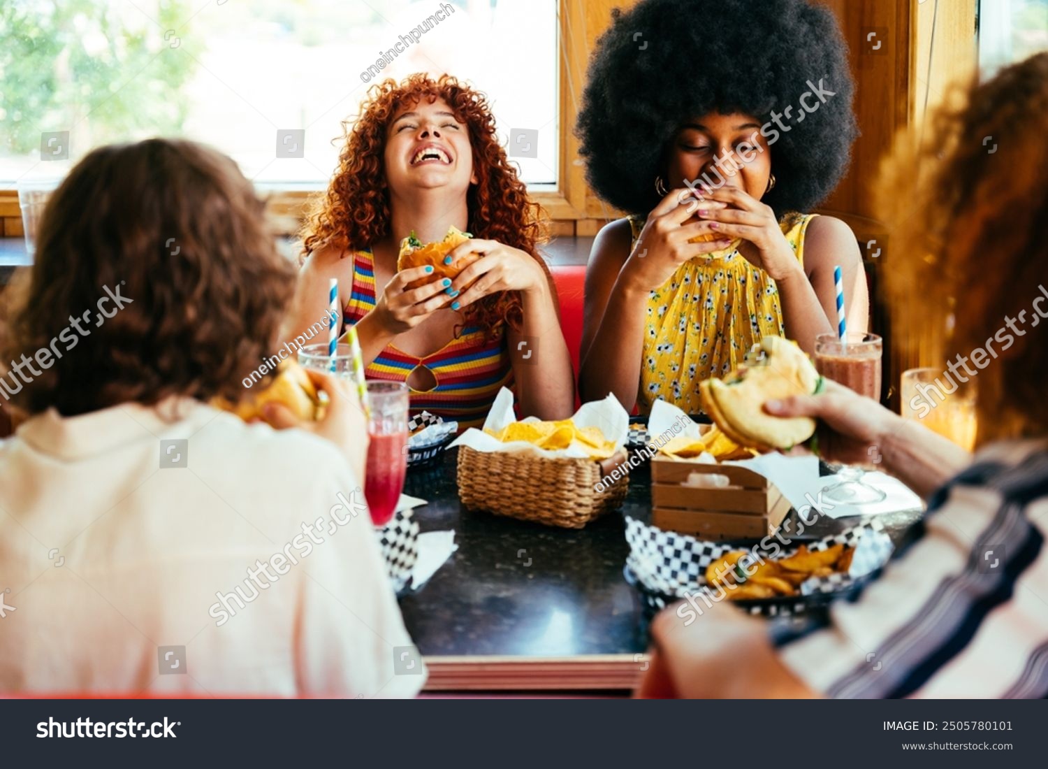 Multiethnic group of friends having meal at 80s vintage diner restaurant - Multiracial young ...