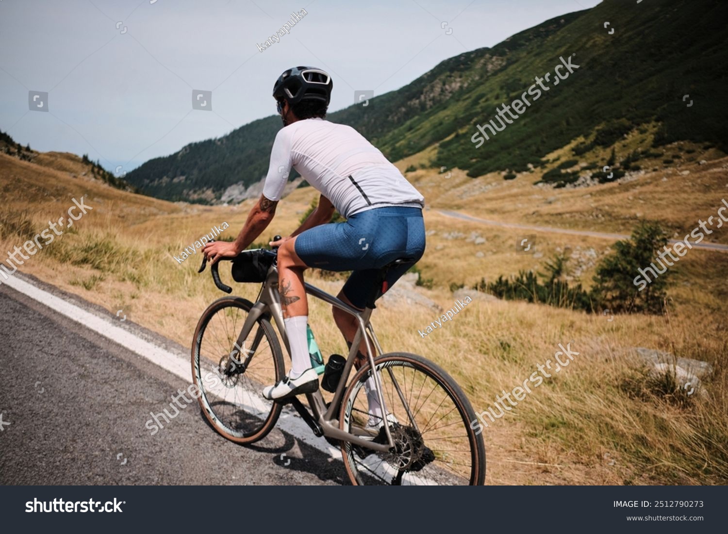 Man cyclist is riding bicycle on Transfagarasan road. A cyclist is practicing cycling. Sport ...