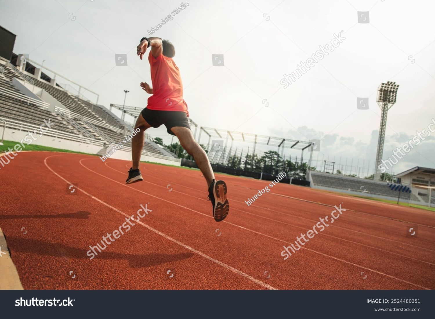The runer runs on a red rubber running track starting off using the ...