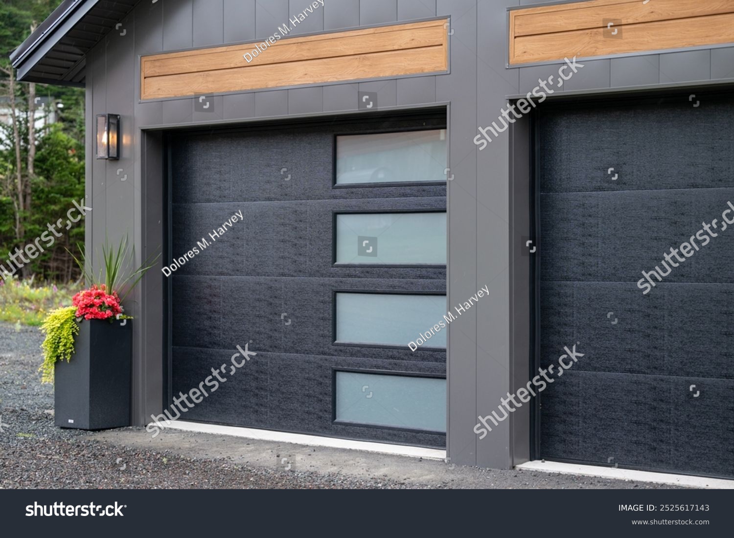 A modern black panel metal exterior garage doors with four small horizontal frosted glass ...
