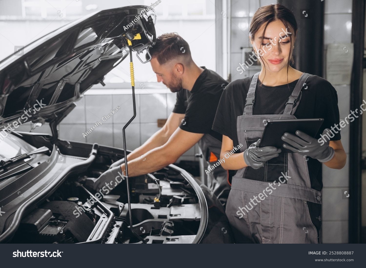 Auto service repair maintenance concept. Mechanic checks the car at the service station ...