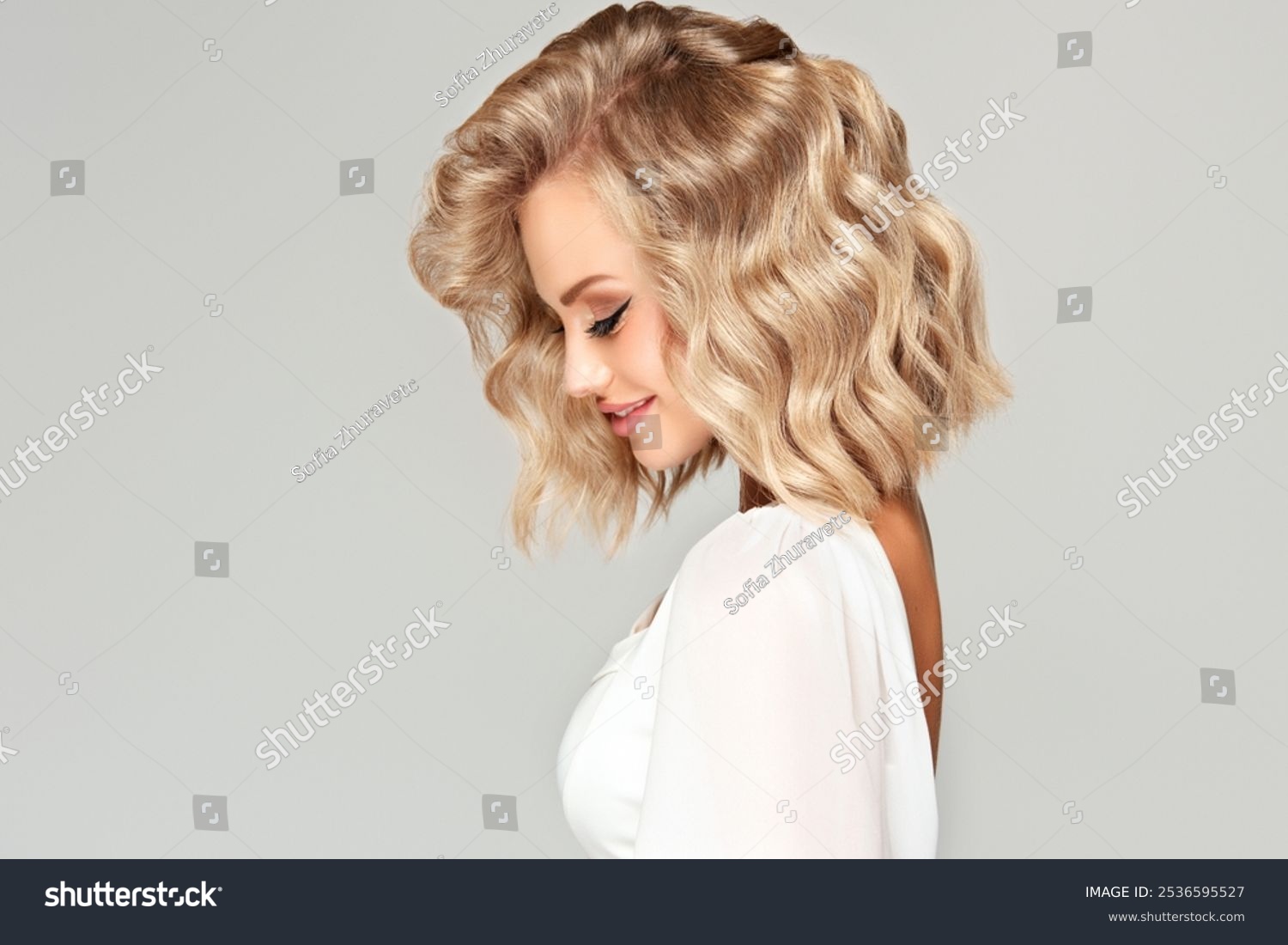 Beautiful blonde model girl with short curly hair . Smiling woman hairstyle wavy curls . Fashion ...