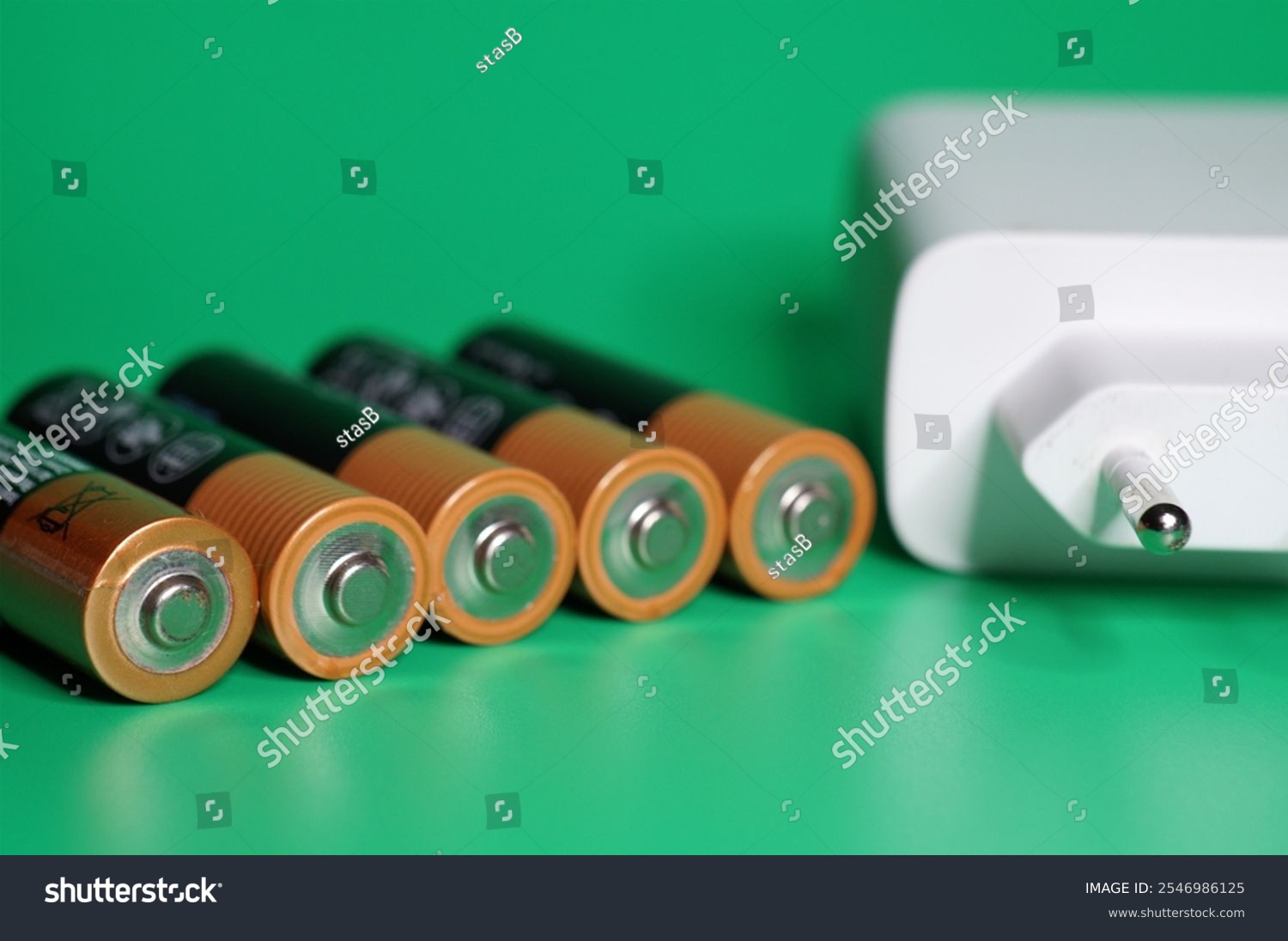 Finger batteries with a charger on a green background._站酷海洛_正版图片_视频_字体 ...