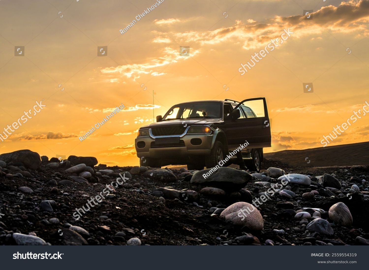 SUV off-road vehicle on foothill rocky off-road at dawn. Road trip ...