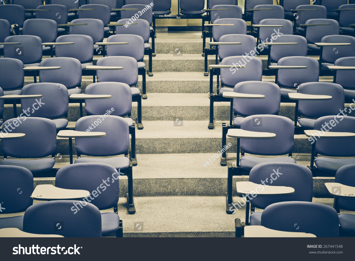 Lecture chairs in a class room with stair path in the middle of a class ...