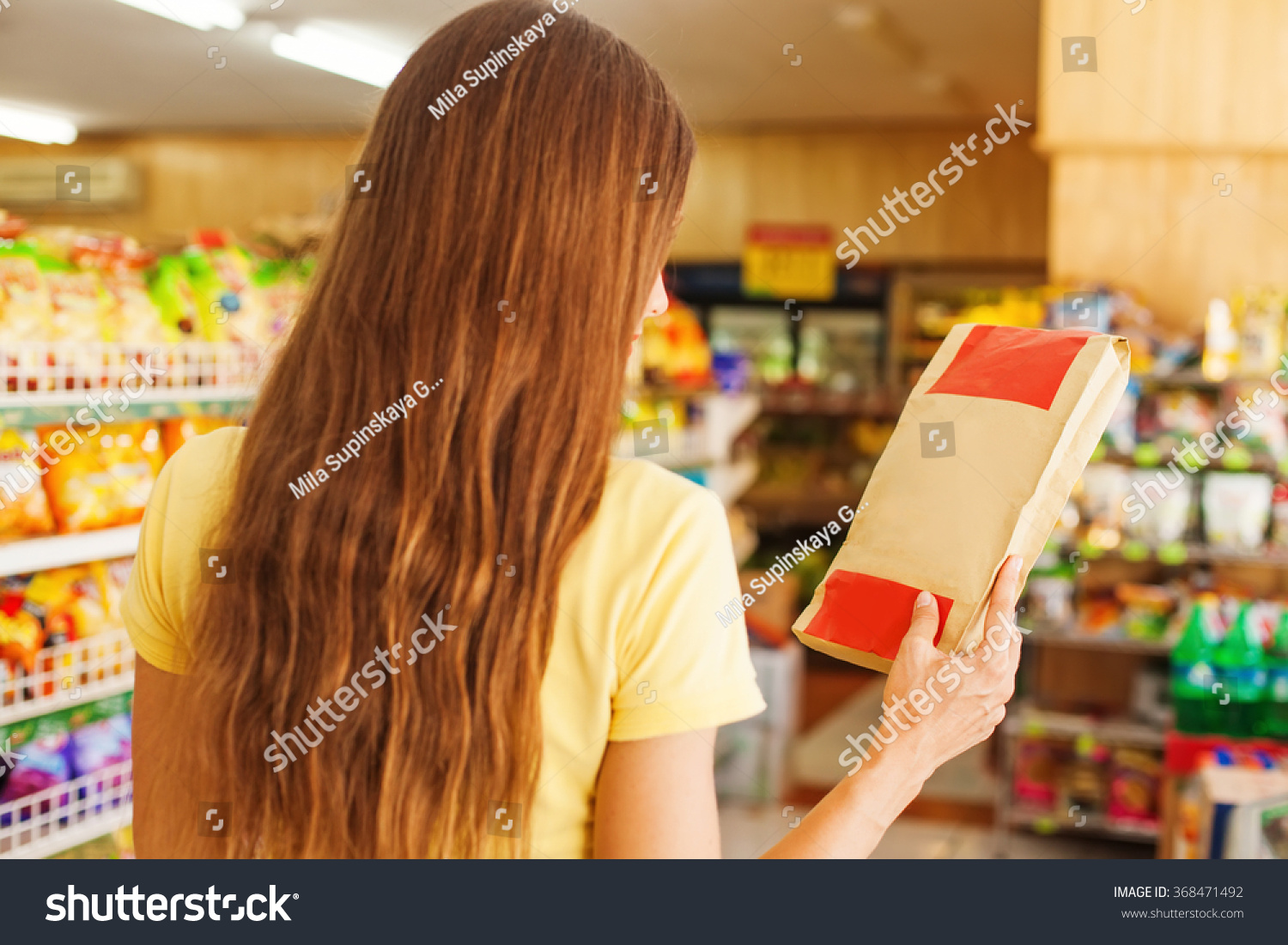 woman reading ingredients from the blank package in shop_站酷海洛_正版图片_视频 ...