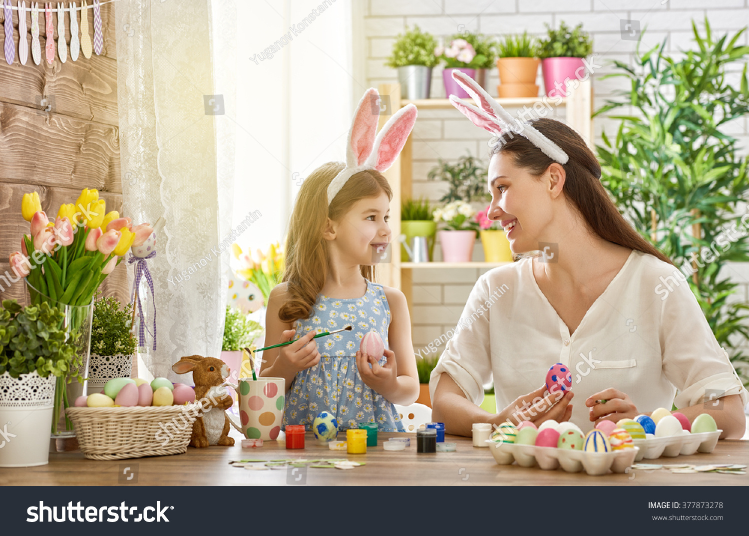 Happy easter! A mother and her daughter painting Easter eggs. Happy ...