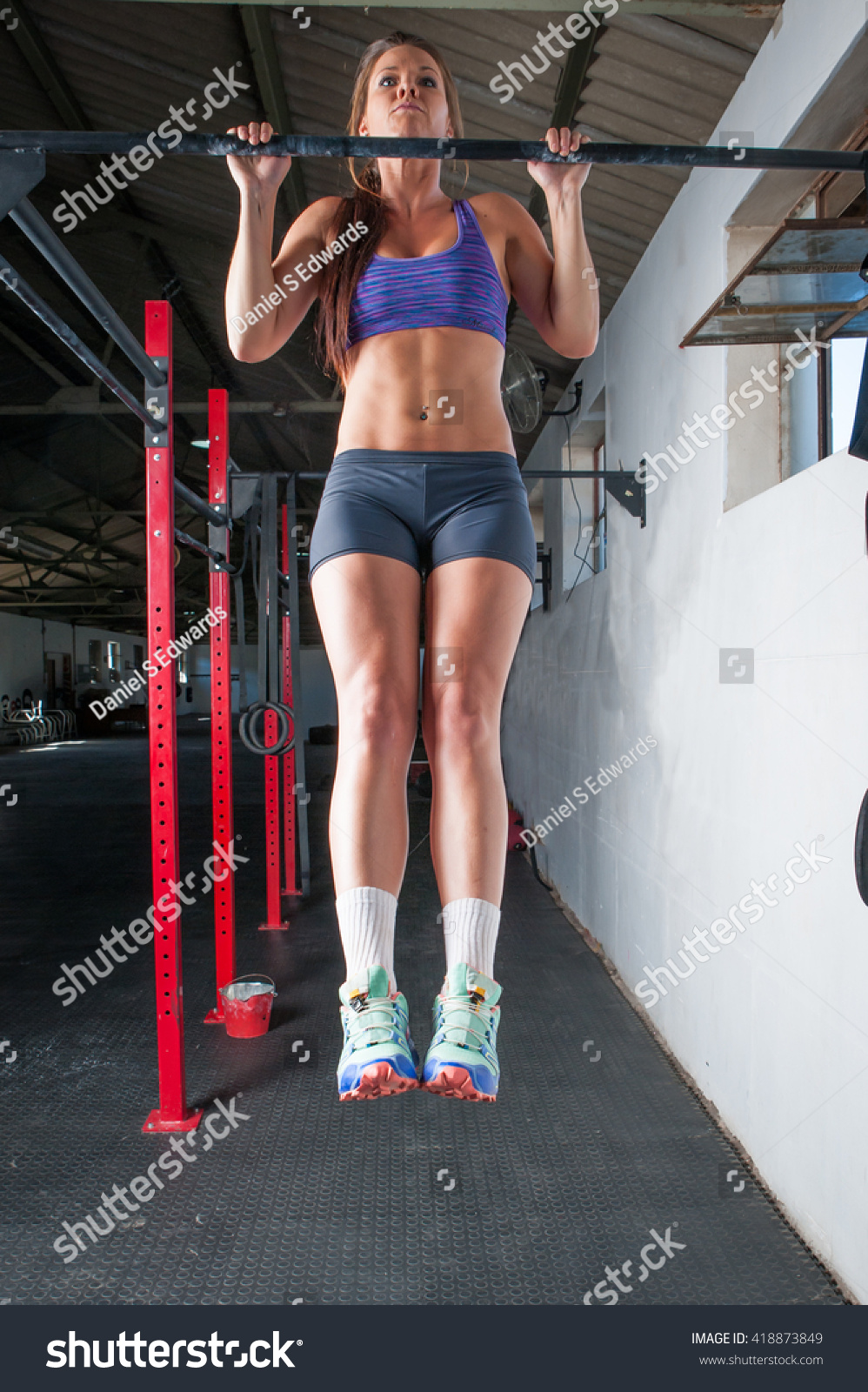 athlete doing pull-up on on a crossbeam - horizontal bar. Female ...