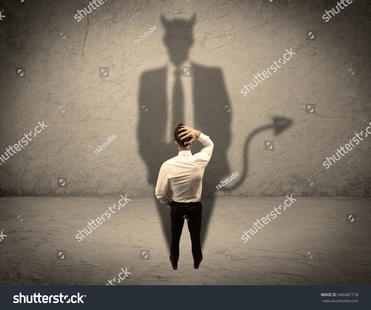 An experienced tricky businessman in suit looking at his devil desguise ...