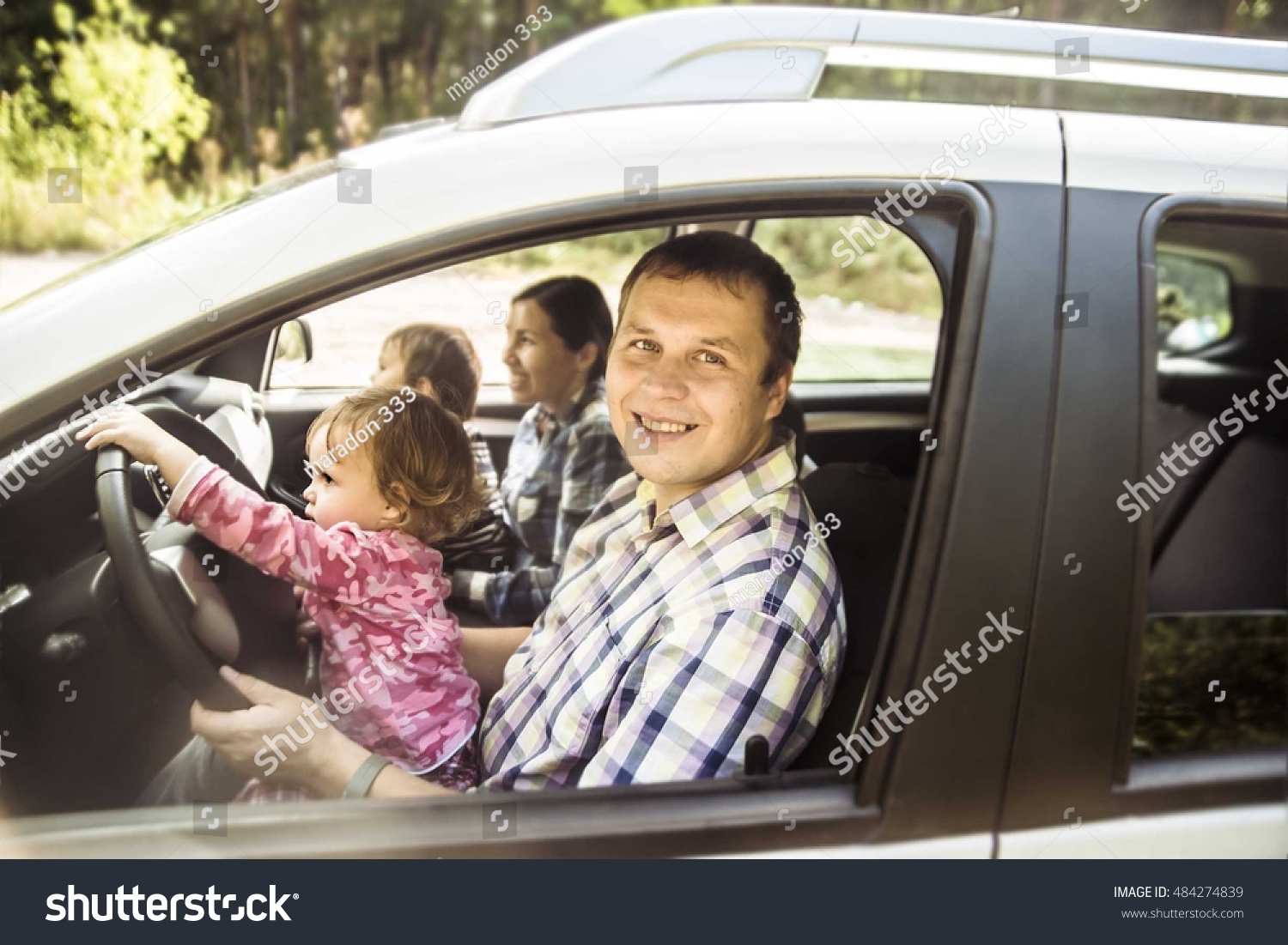 Mother father and children - son and daughter pretend driving car ...