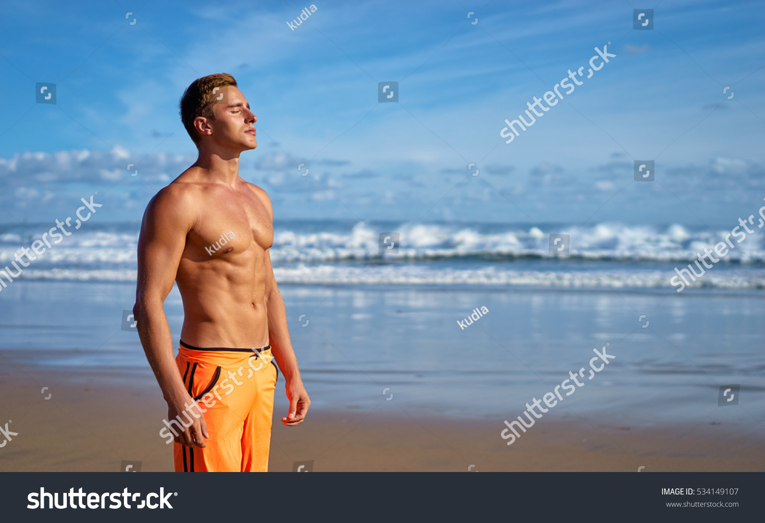 Enjoying the sea and sun. Handsome and strong young man tanning on the beach._站酷海洛_正版图片_视频_字体_音乐 ...