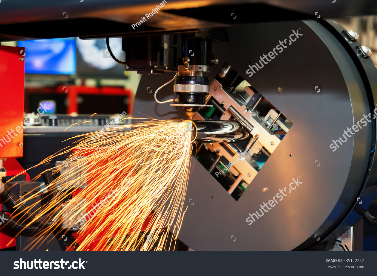 CNC laser cutting metal pipe with bright sparkle in factory. Industry ...