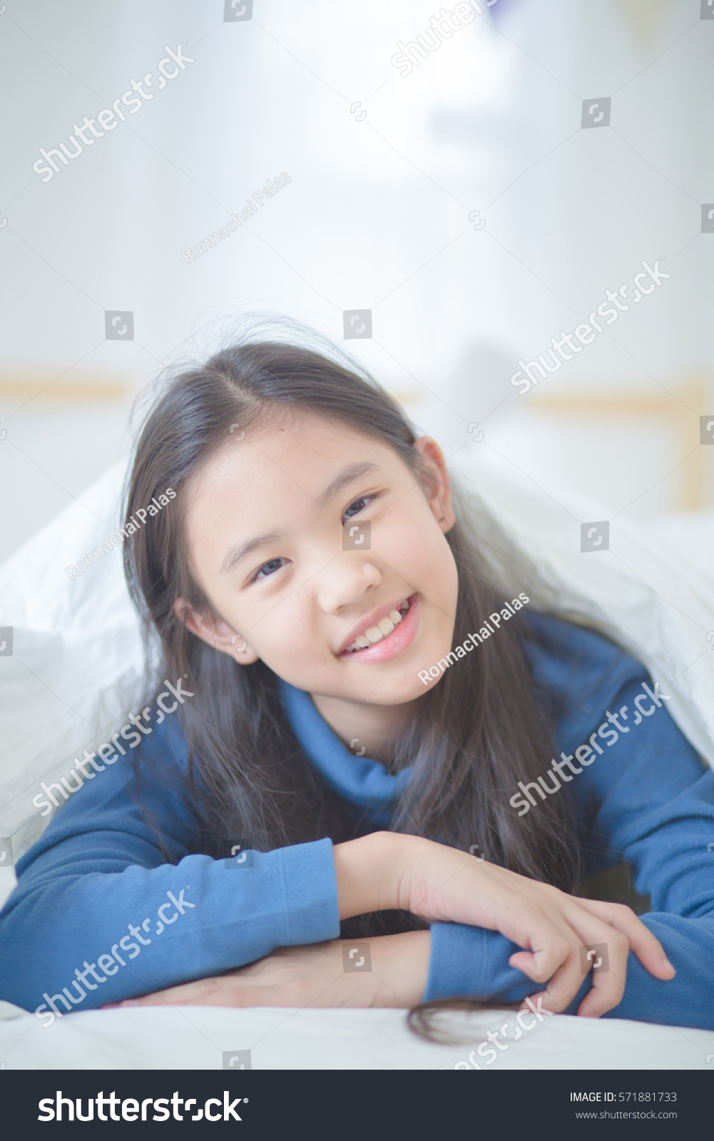 Happy Asian girl lying on the bed with sun light on lazy day_站酷海洛_正版图片_视频_字体_音乐素材交易平台_站酷旗下品牌