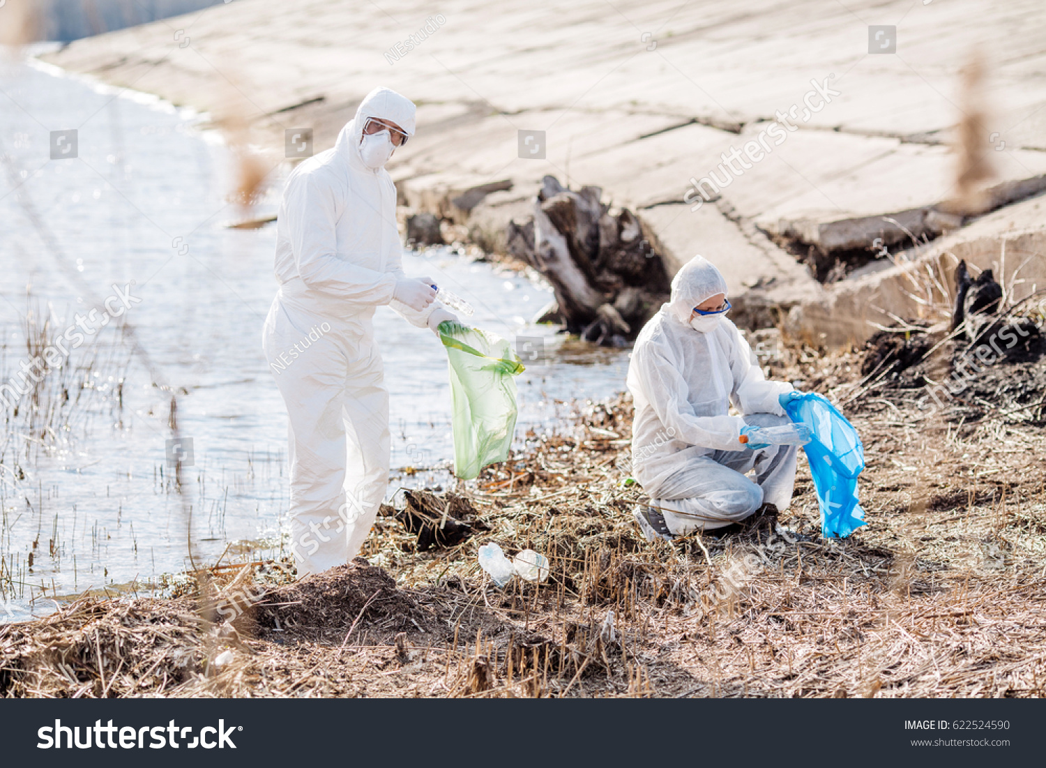 Ecologist working together on on dirty beach of the lake. Ecology and ...