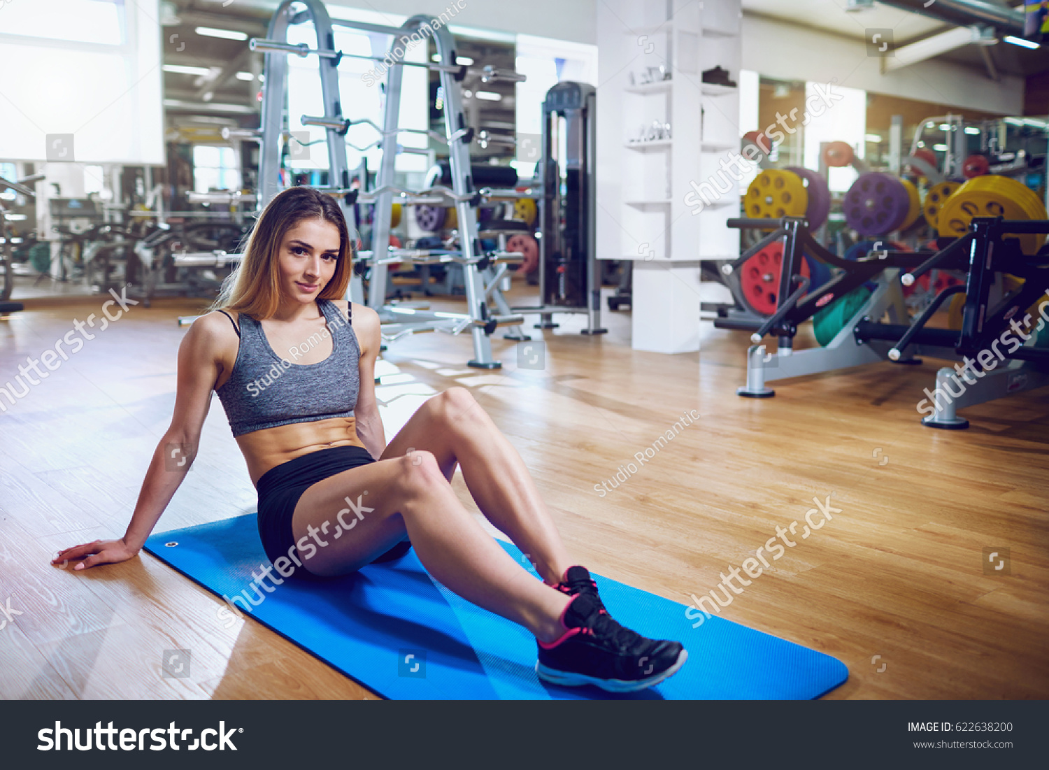 A sporty girl sits on the floor in the gym after workout_站酷海洛_正版图片_视频_字体_音乐素材交易平台_站酷旗下品牌