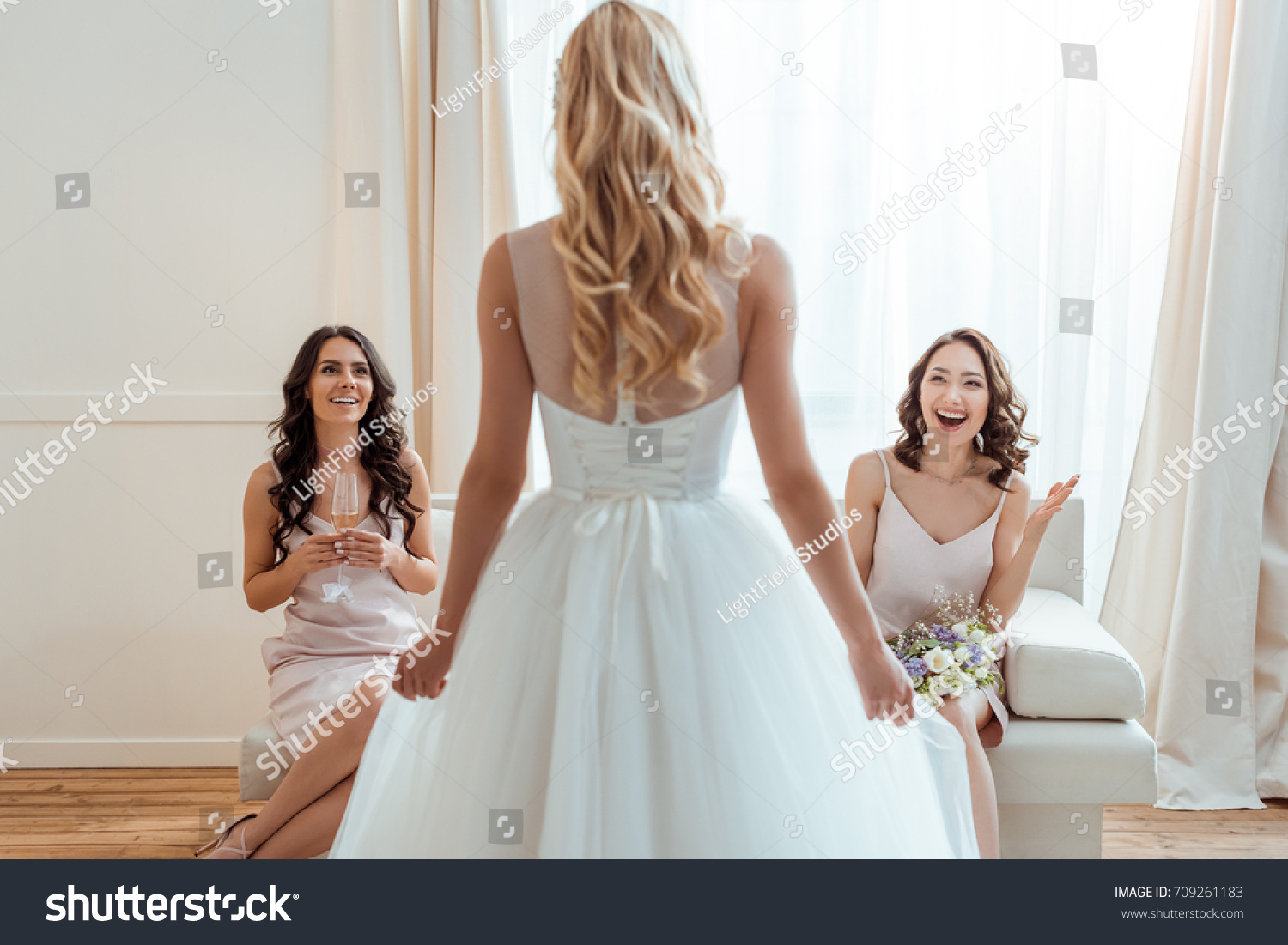 beautiful excited bridesmaids looking at beautiful bride in dress_站酷海洛 ...