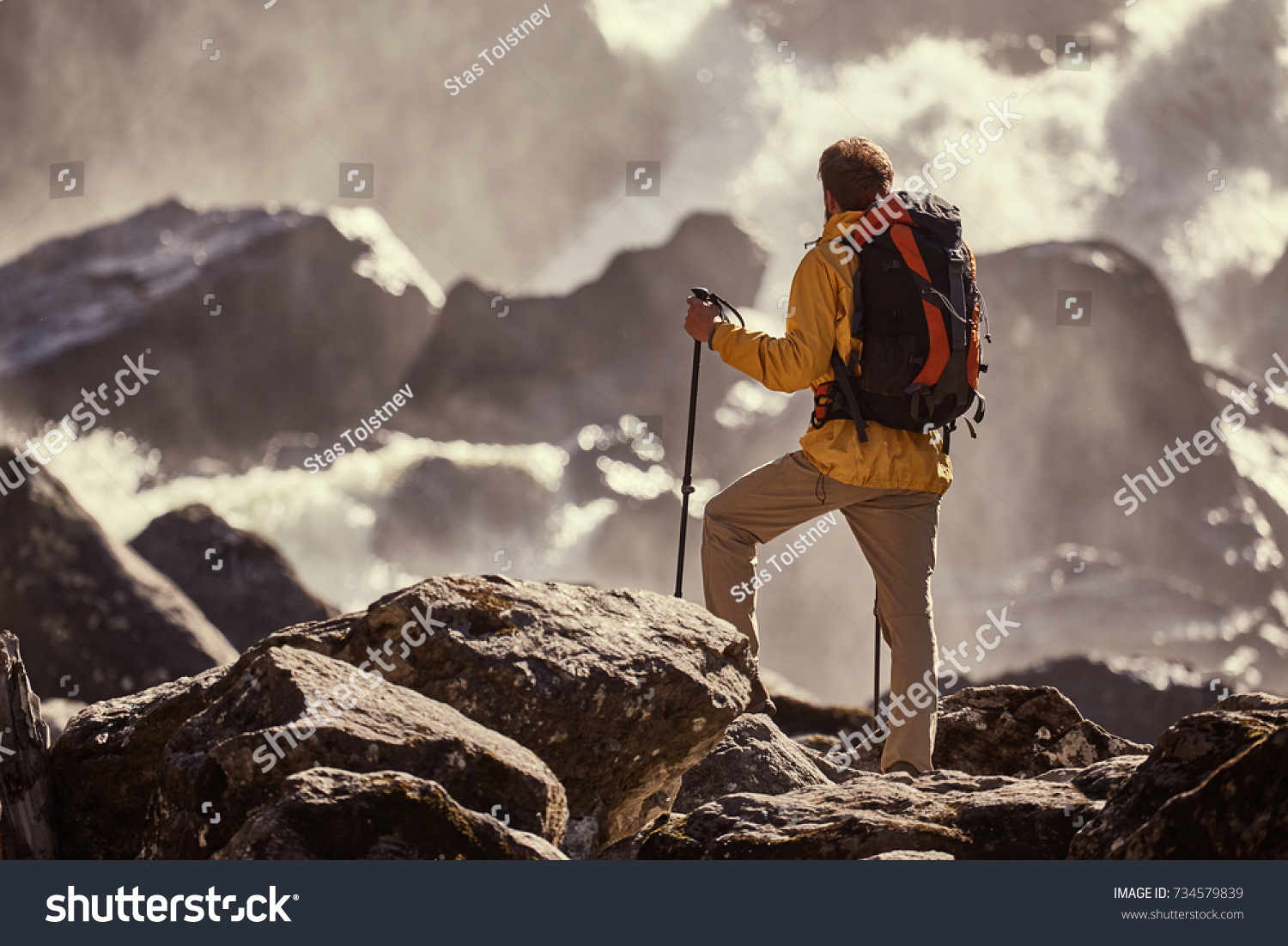 Hiker hiking with backpack looking at waterfall in park in beautiful ...