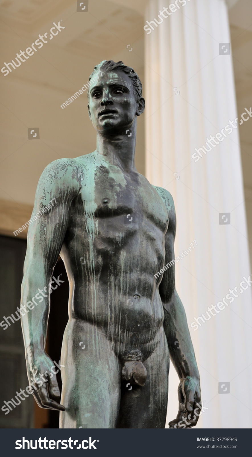athletic male bronze statue with a longing stare in front of greek ...