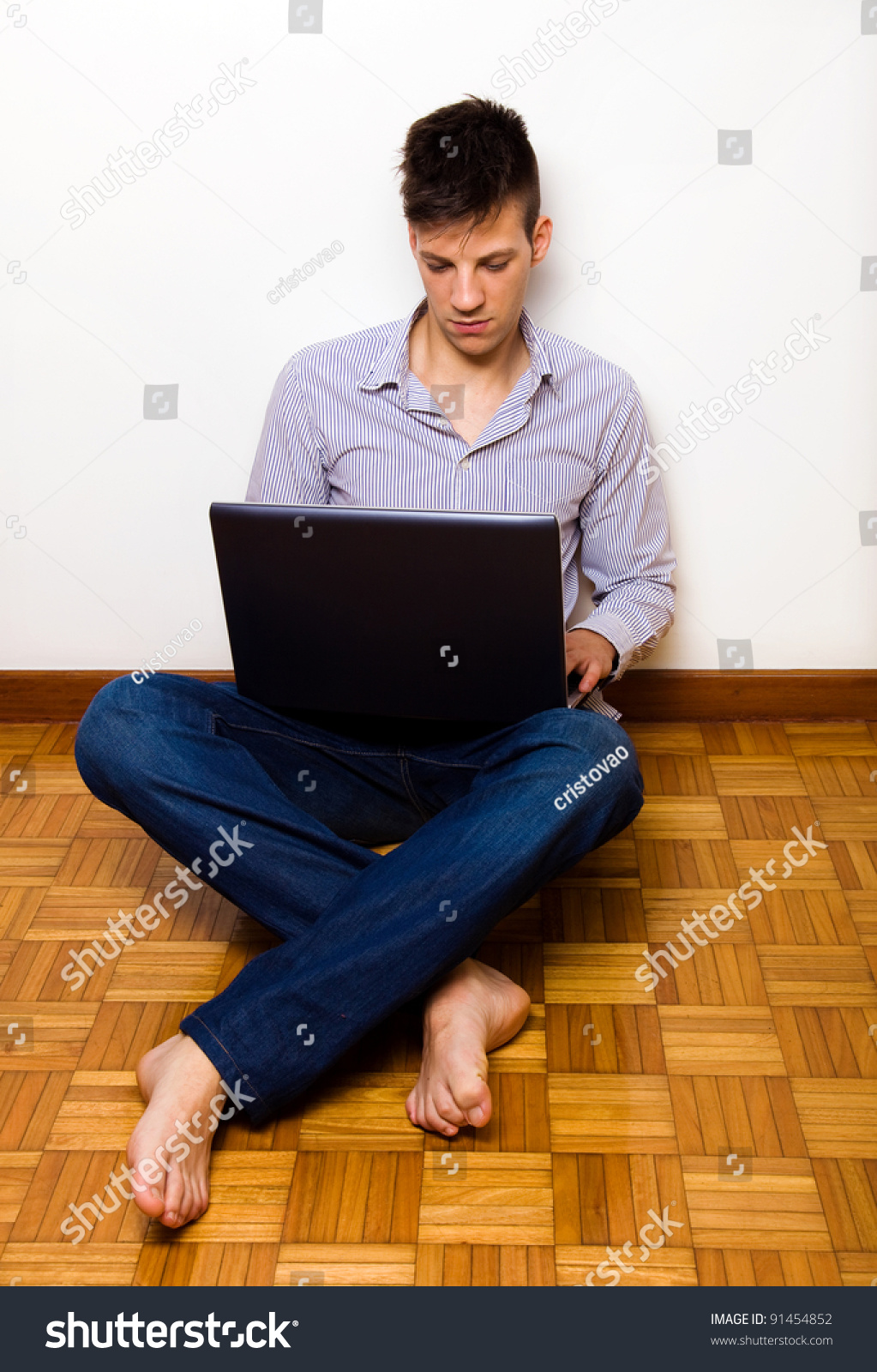 young man sitting on the floor working on laptop computer at home_站酷海洛 ...